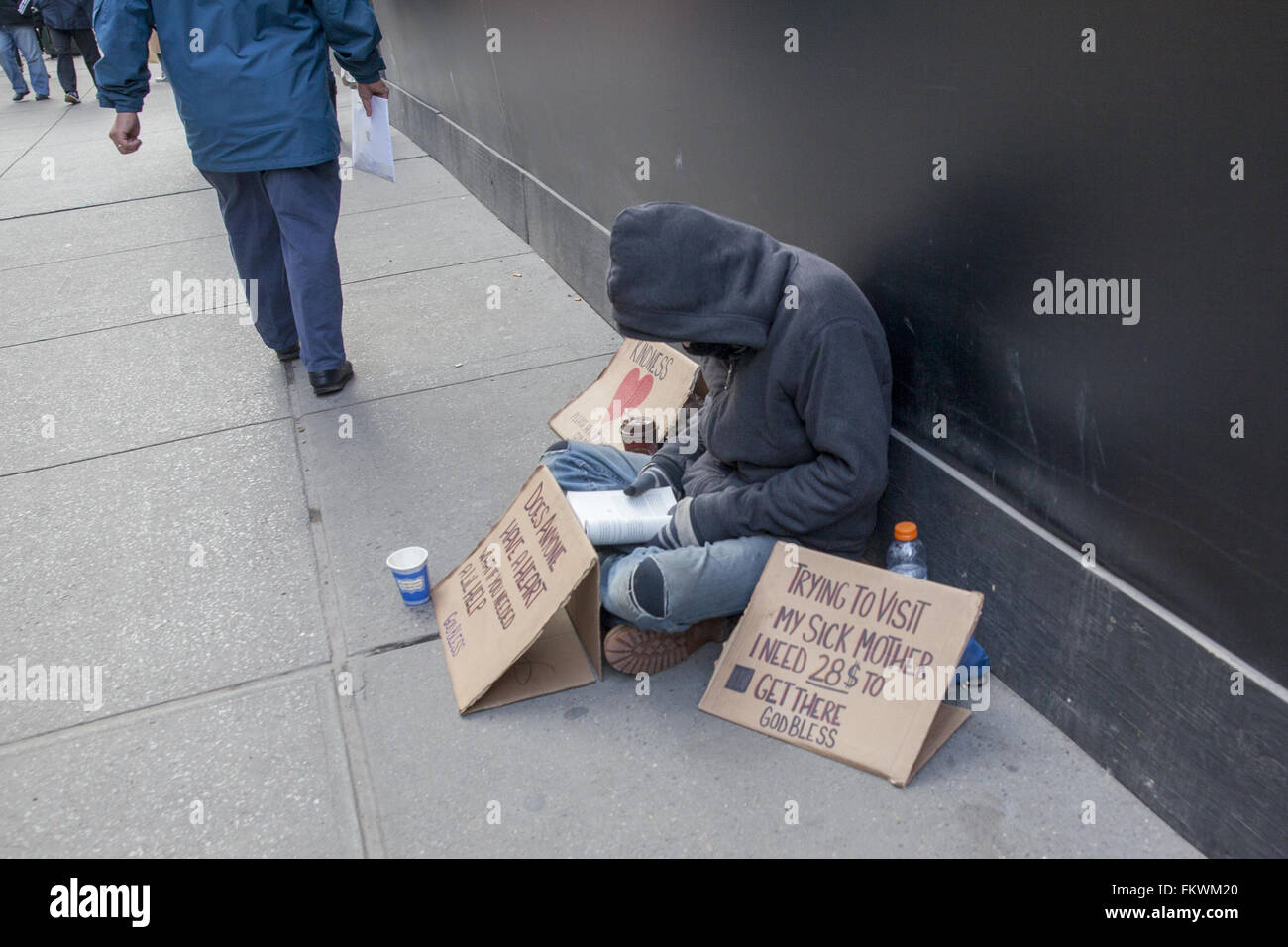 Penniless man begs on 5th Avenue in NYC with signs asking for help to ...