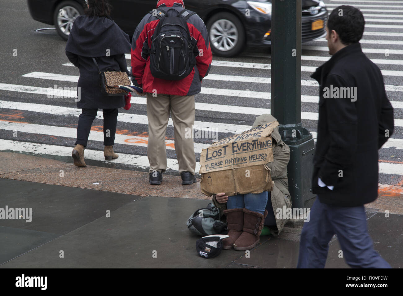 Person reaches out for help with a sign as the constant flow of ...