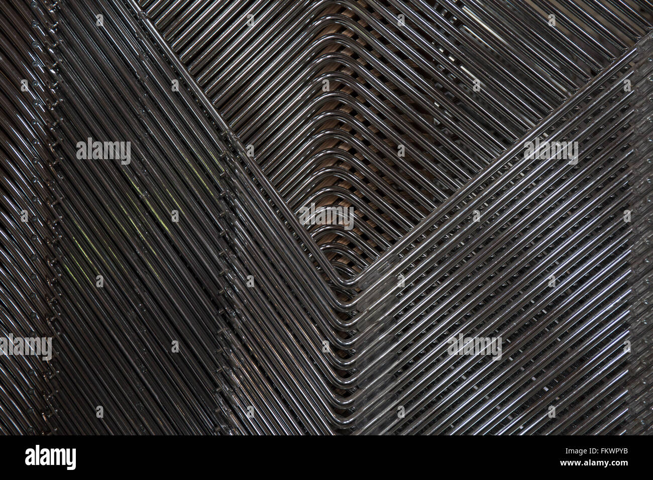 Chairs with bright steel legs are stacked together with lights ...