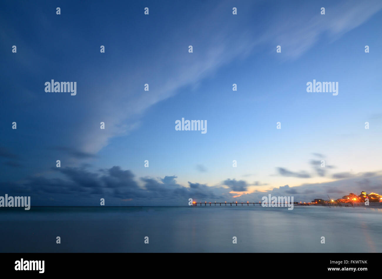 Long pier during twilight in blue tones with some city lights Stock ...