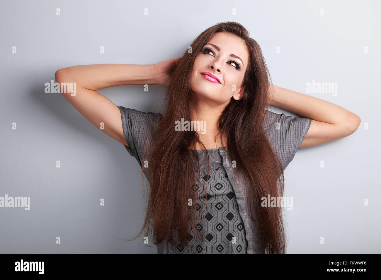 Thinking make-up beautiful female model relax near the wall on blue ...