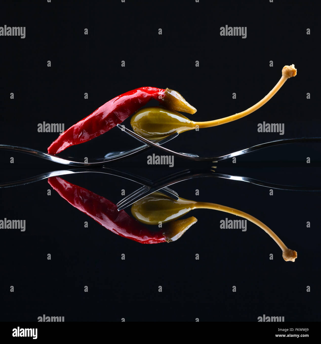 canned capers and pepper on a black reflective background Stock Photo ...