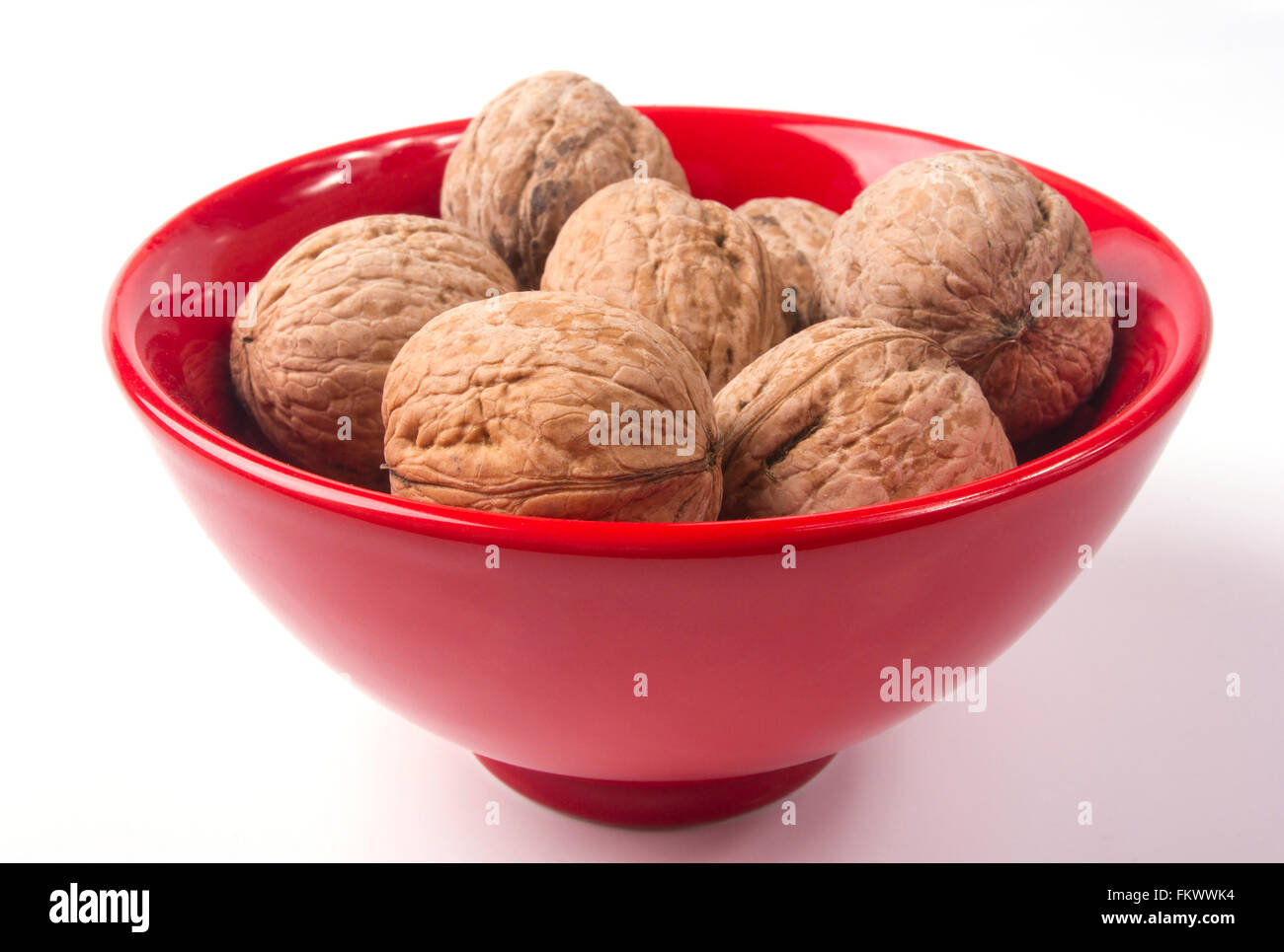 walnuts in red plate on white background Stock Photo - Alamy