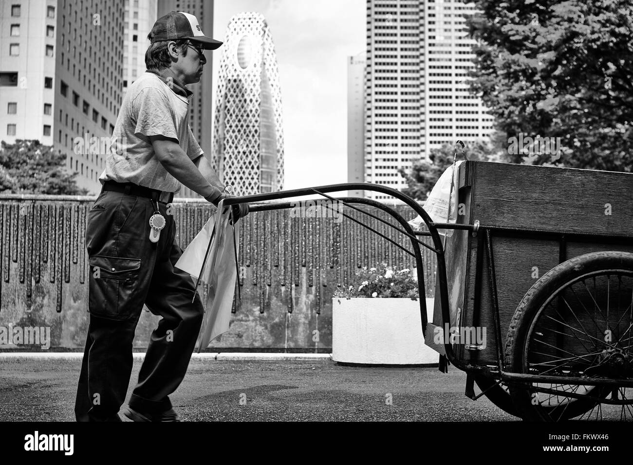 Japanese man pushing a handcart before skyscrapers Stock Photo - Alamy