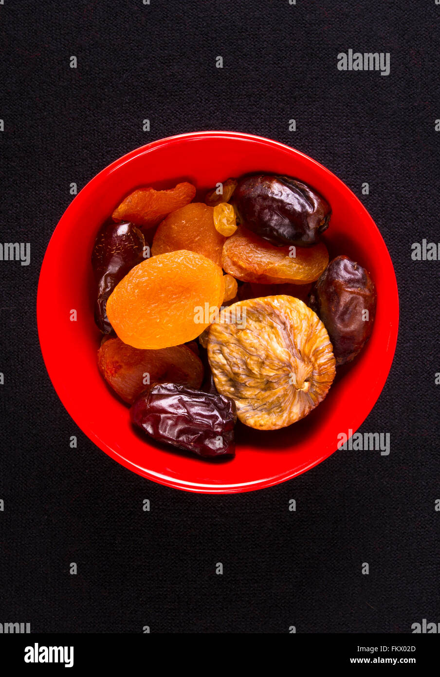 various dried fruits in red plate on the black background Stock Photo ...