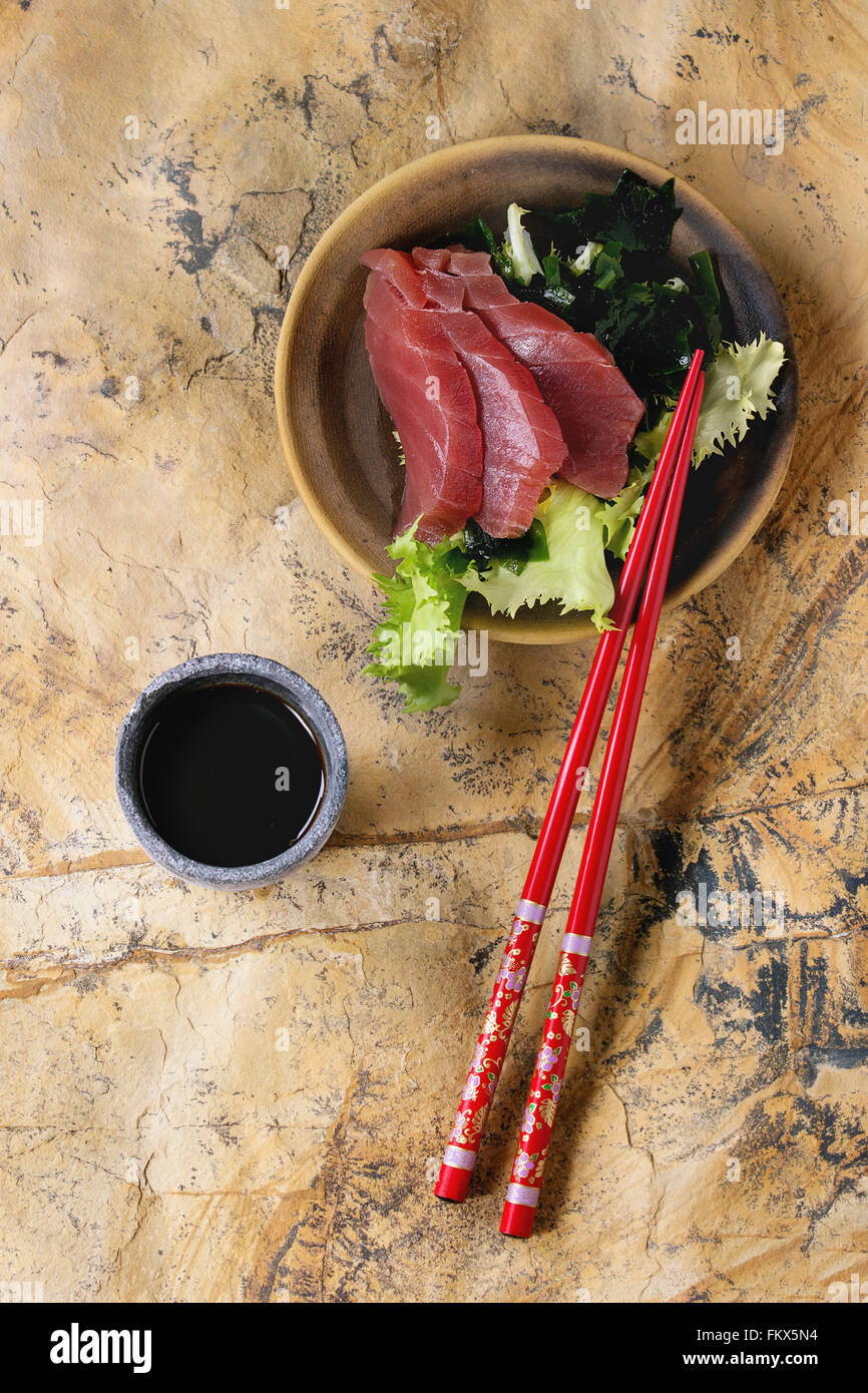 Sashimi Tuna on clay plate served with chopsticks and soy sauce on ...