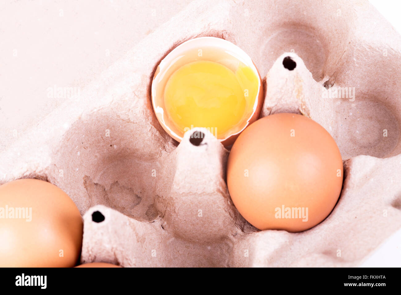 broken egg in a container with egg yolk Stock Photo - Alamy