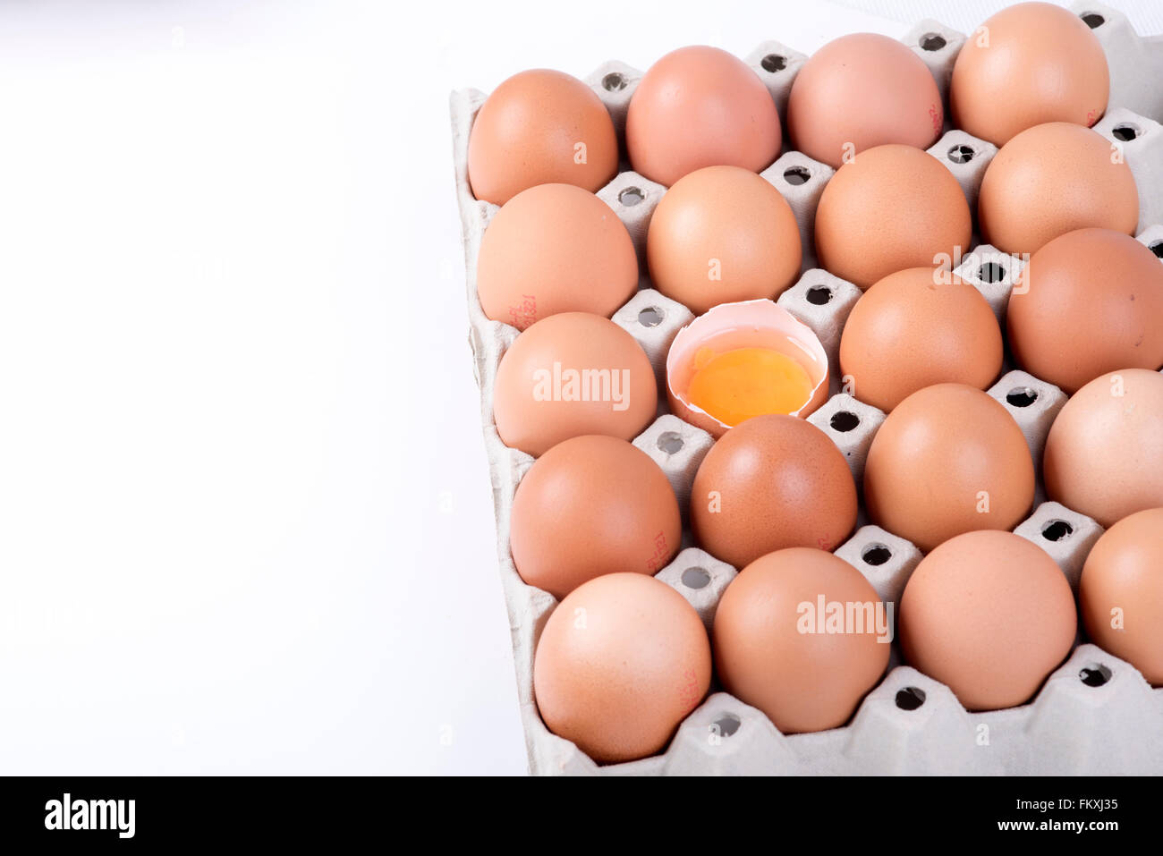 broken egg in a container with egg yolk Stock Photo - Alamy