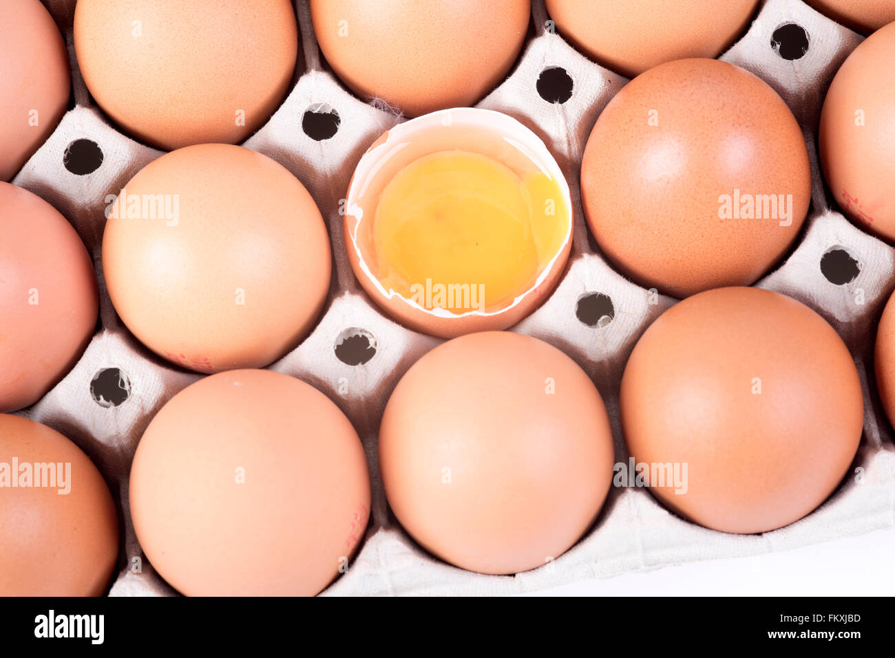 broken egg in a container with egg yolk Stock Photo - Alamy