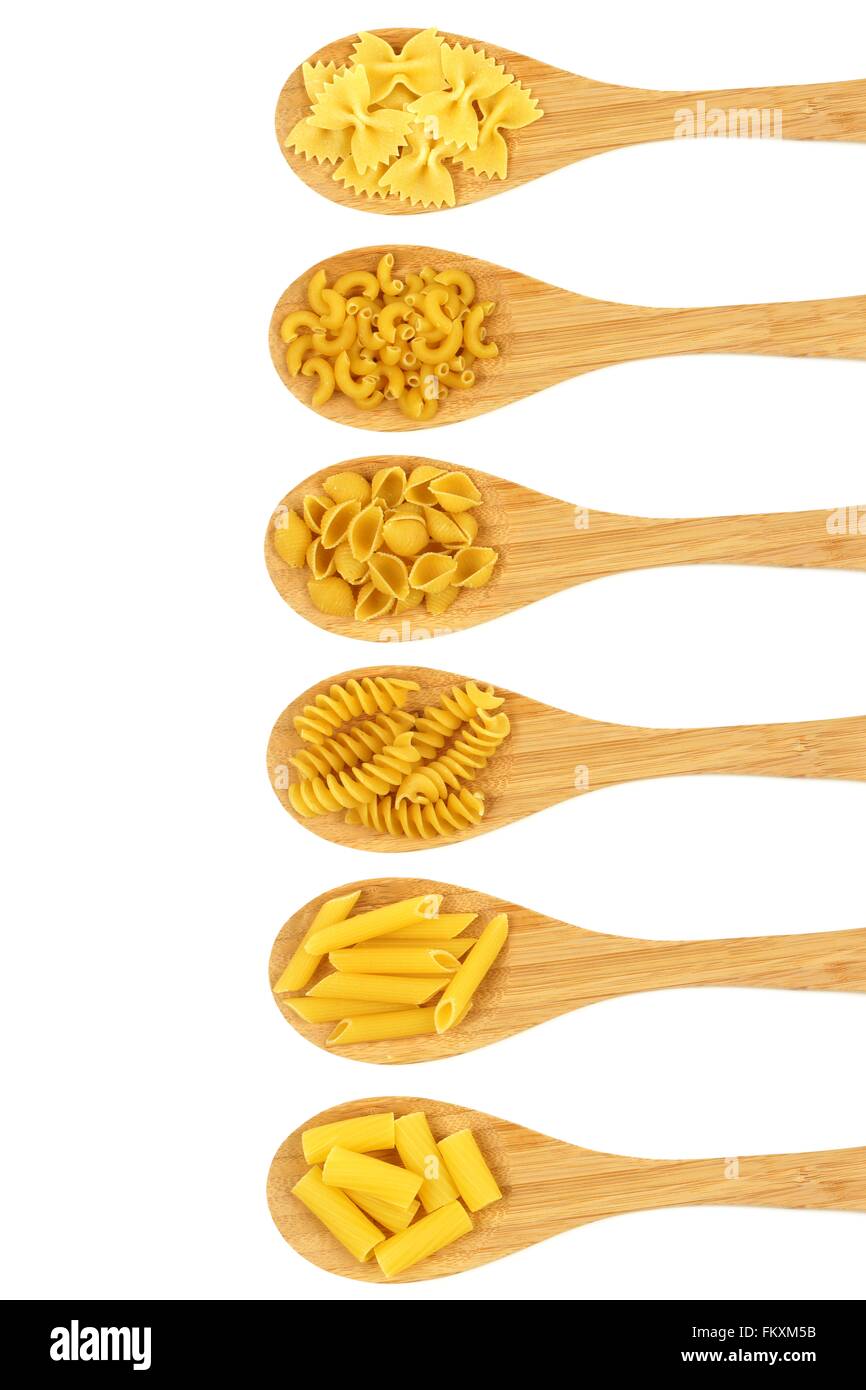 Spoons filled with various dry pasta over a white background Stock ...