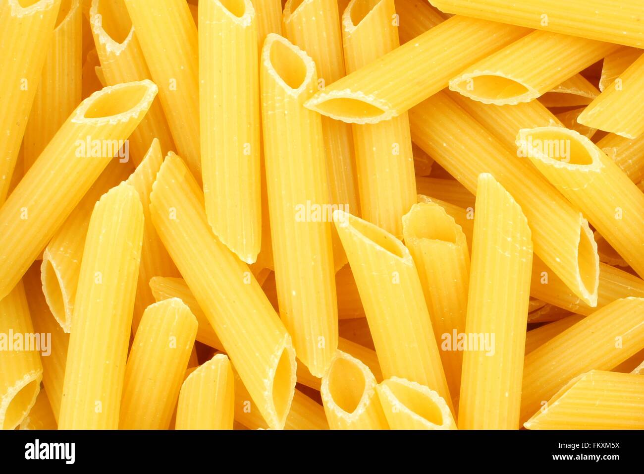 Full background of dry uncooked penne pasta Stock Photo - Alamy