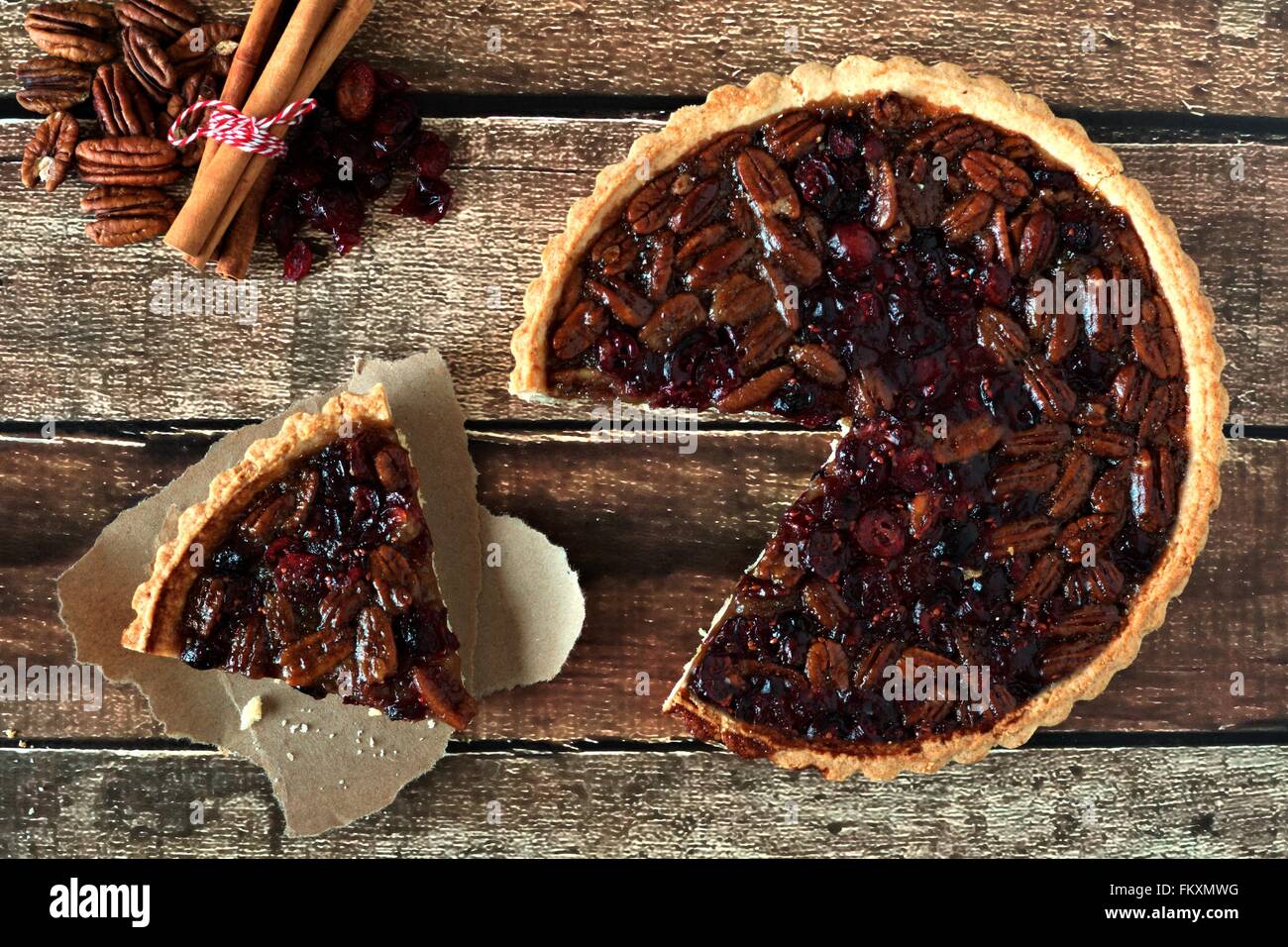 Pecan and cranberry autumn pie, overhead table scene with cut slice on ...