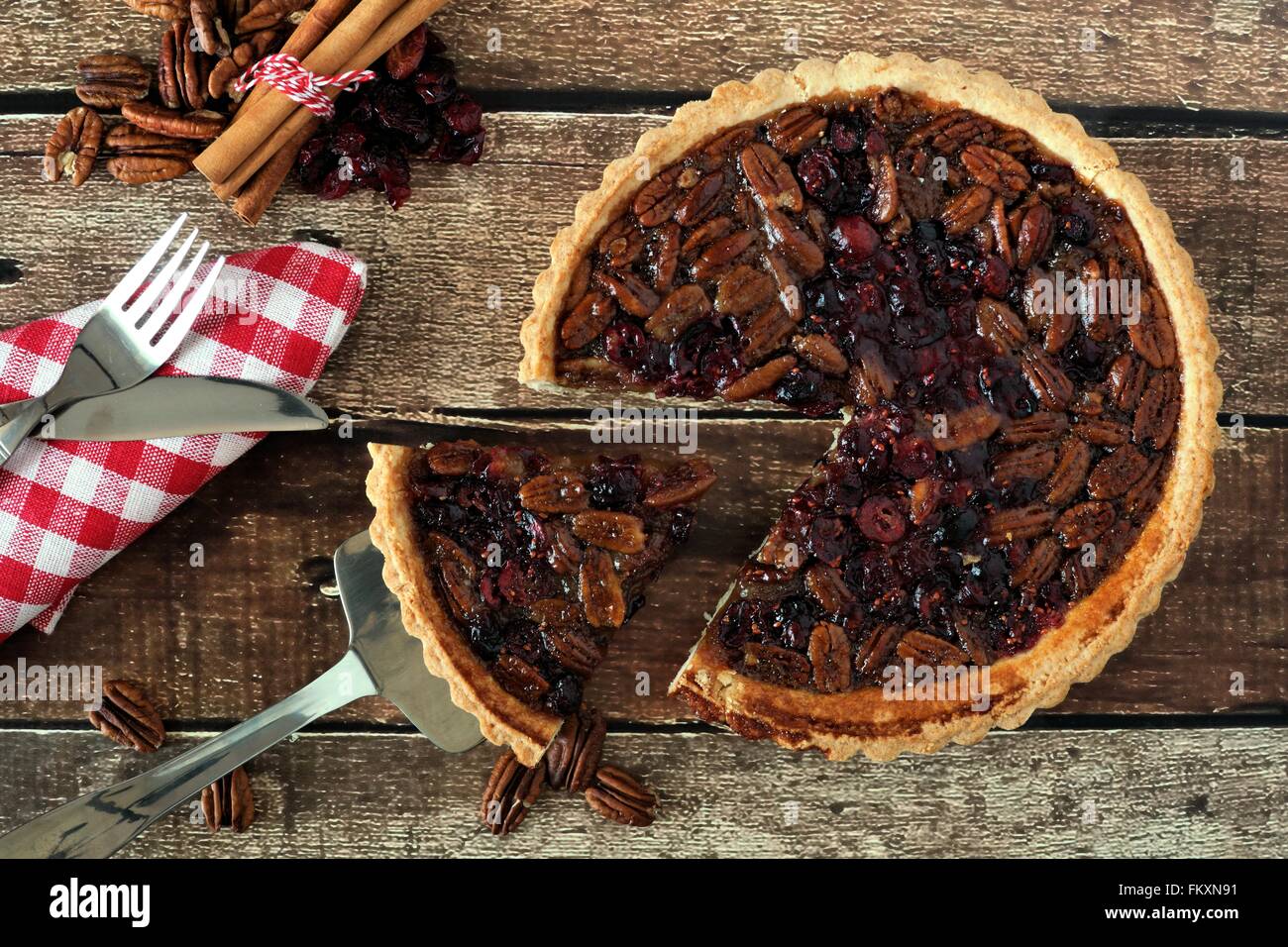 Pecan and cranberry autumn pie, overhead table scene on rustic wood ...