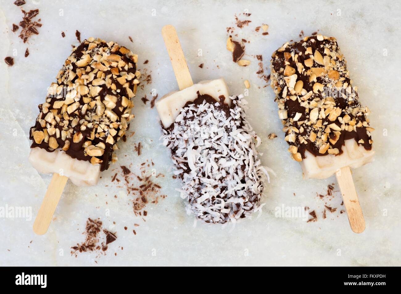 Homemade chocolate dipped popsicles with coconut and nuts. Overhead ...