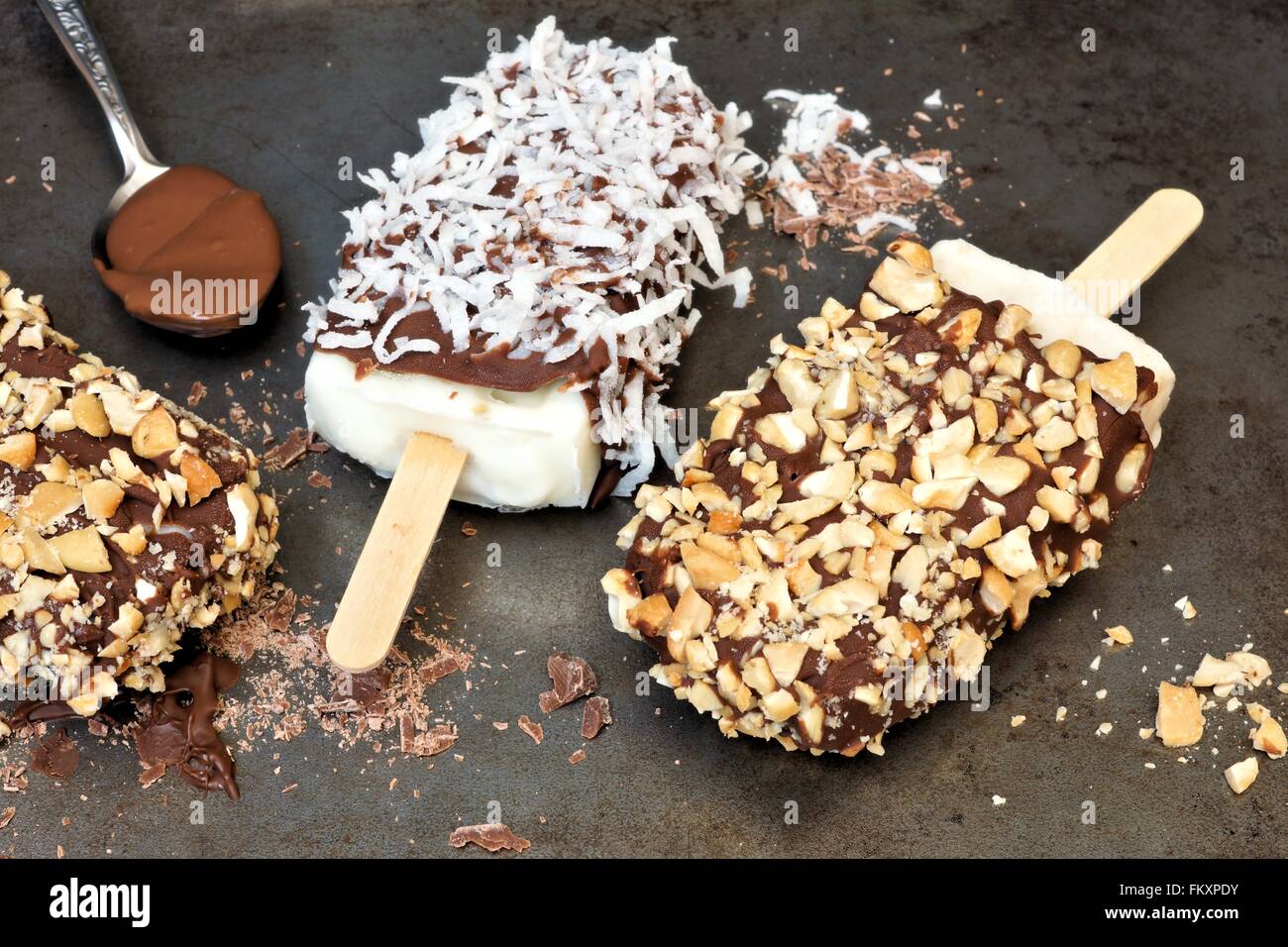 Homemade chocolate dipped popsicles with nuts and coconut against a ...