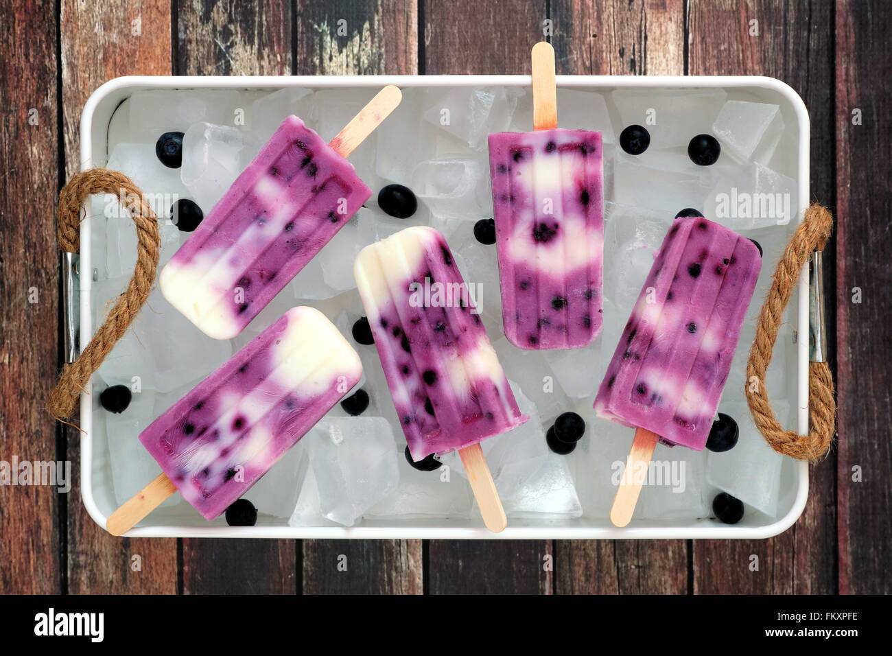 Group of blueberry vanilla ice pops in a vintage ice tray with rustic ...