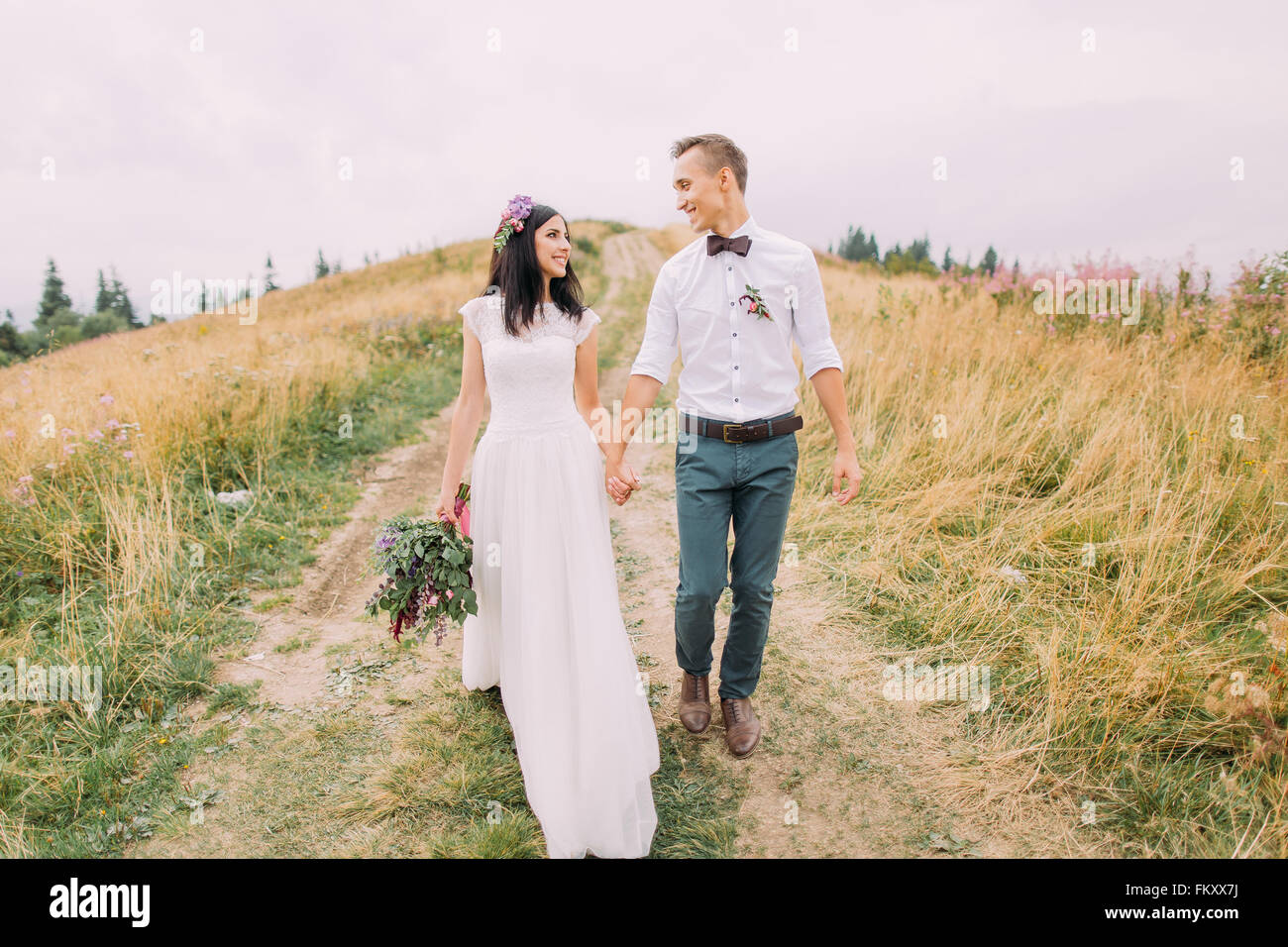 Wedding couple walks on path in the mountains. Honeymoon Stock Photo ...