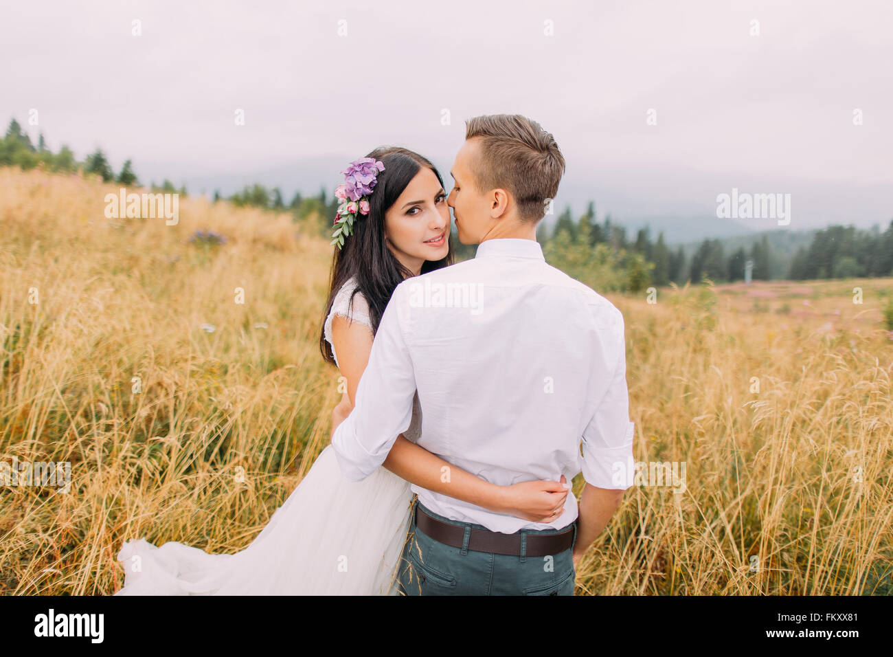 Happy wedding couple hug in the field. Sunny day at mountains Stock ...