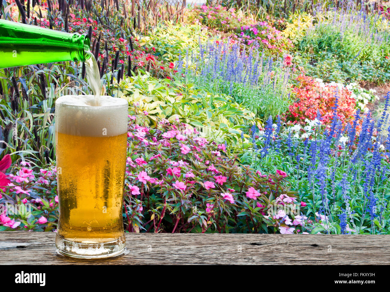 Enjoy beer in colorful flower garden Stock Photo - Alamy