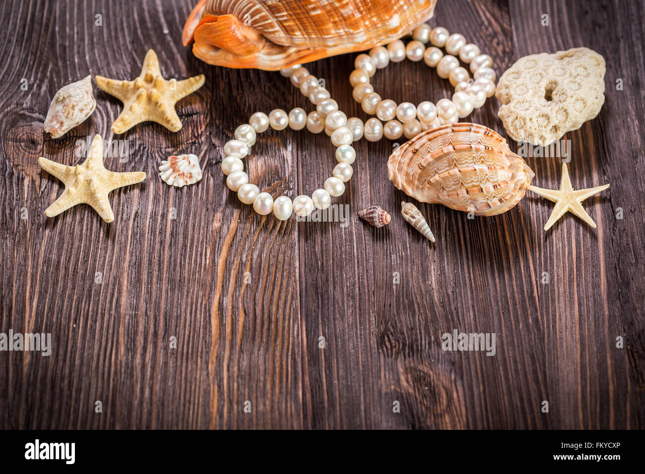 Sea objects - shells, sea stars, pearls on dark wooden background Stock ...
