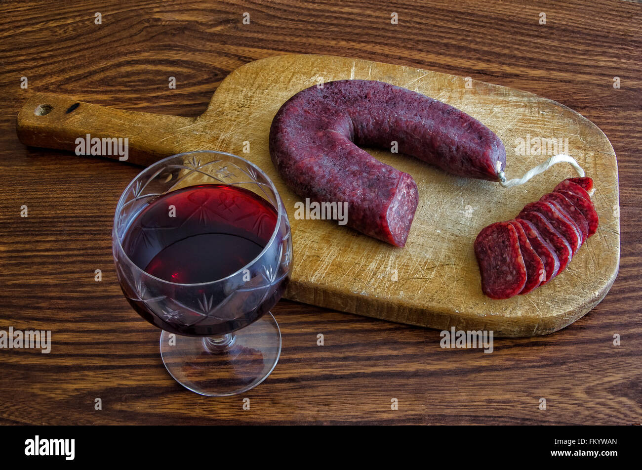 Glass of red wine and sliced Bulgarian salami on a wooden board Stock ...