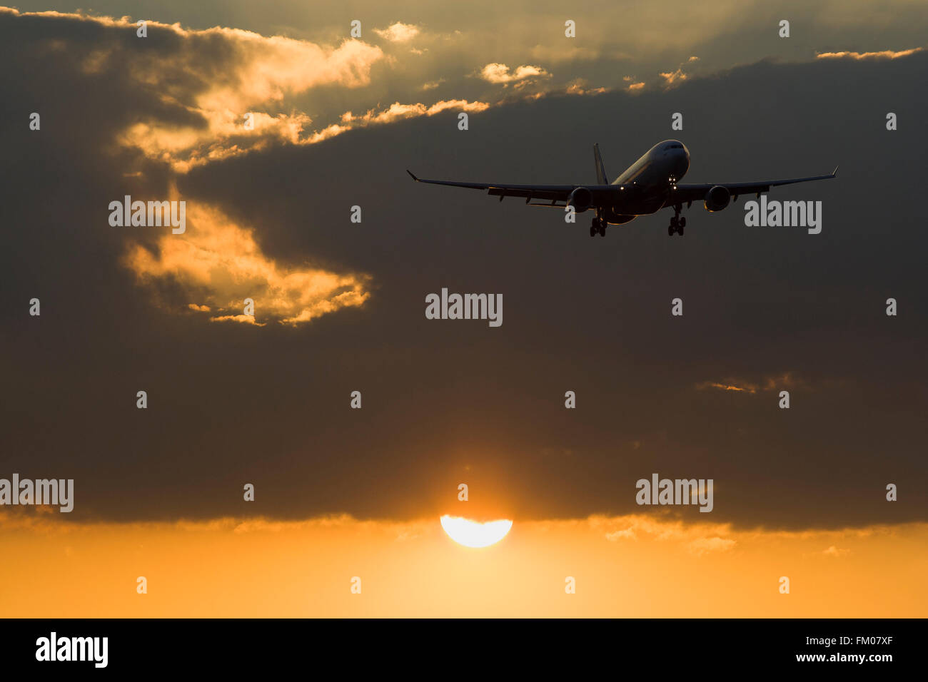Airplane on final approach at Heathrow airport on sunset Stock Photo ...