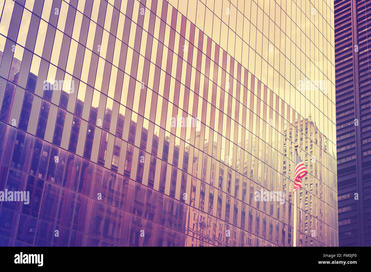 Vintage toned American flag in front of building glass wall, New York ...