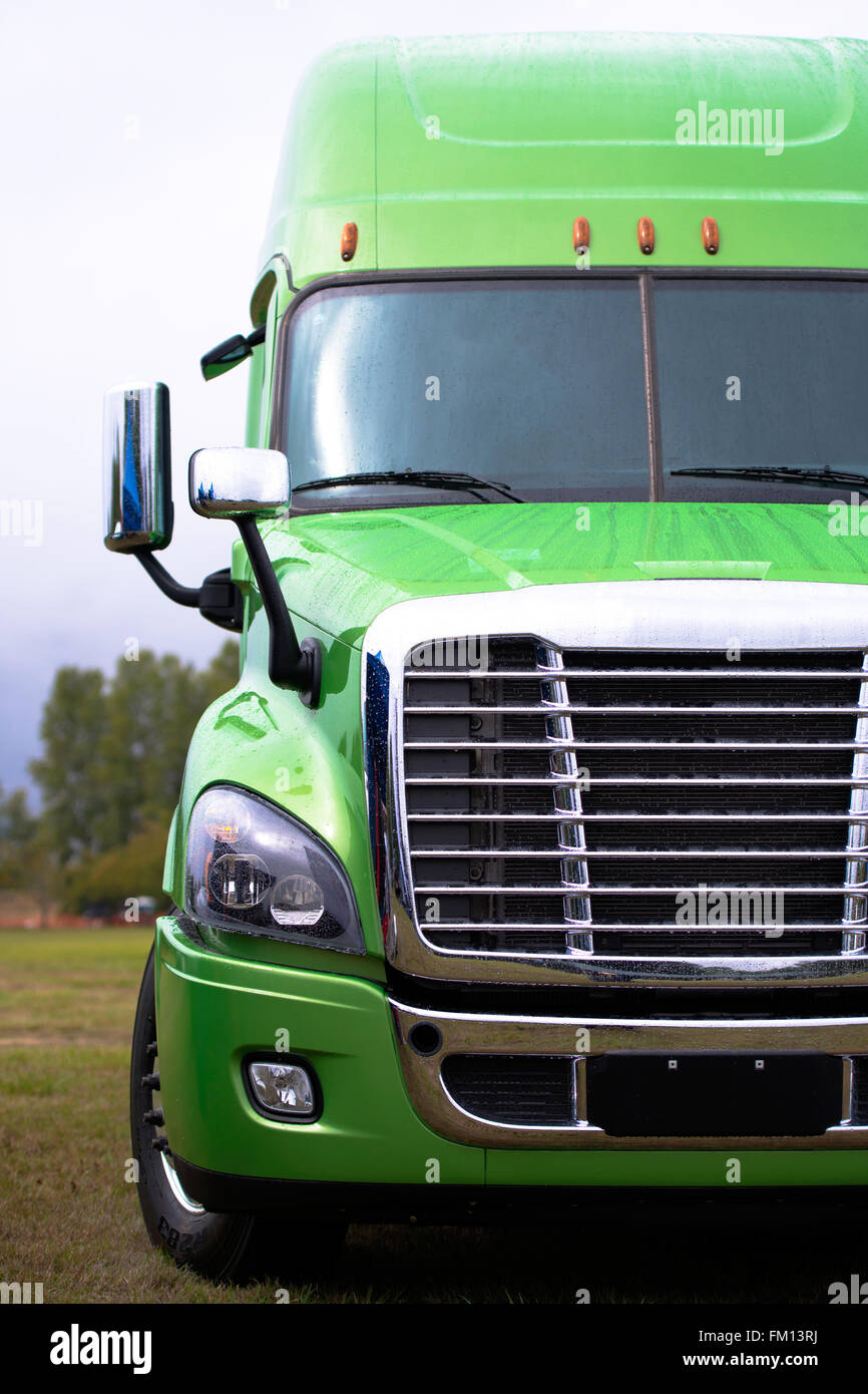 Wet from the rain stylish modern powerful green big rig semi truck with ...