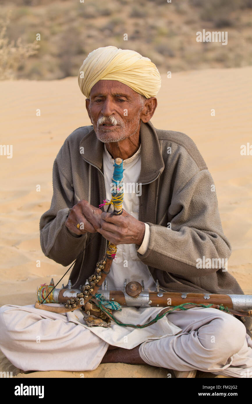 Asia, India, Rajasthan, Manvar,desert, sand dunes. Villager playing ...