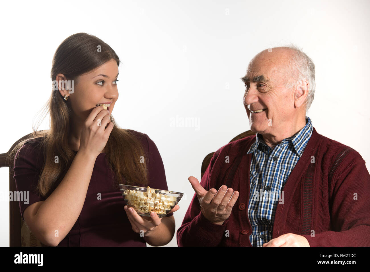 young woman and senior man eat popcorn Stock Photo - Alamy