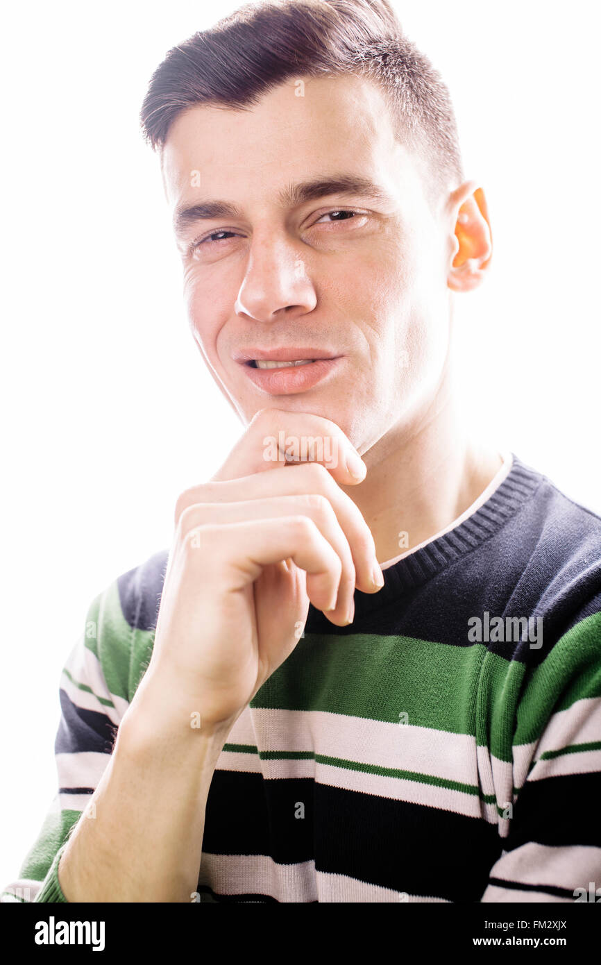 Portrait of a smart serious young man standing against white background ...