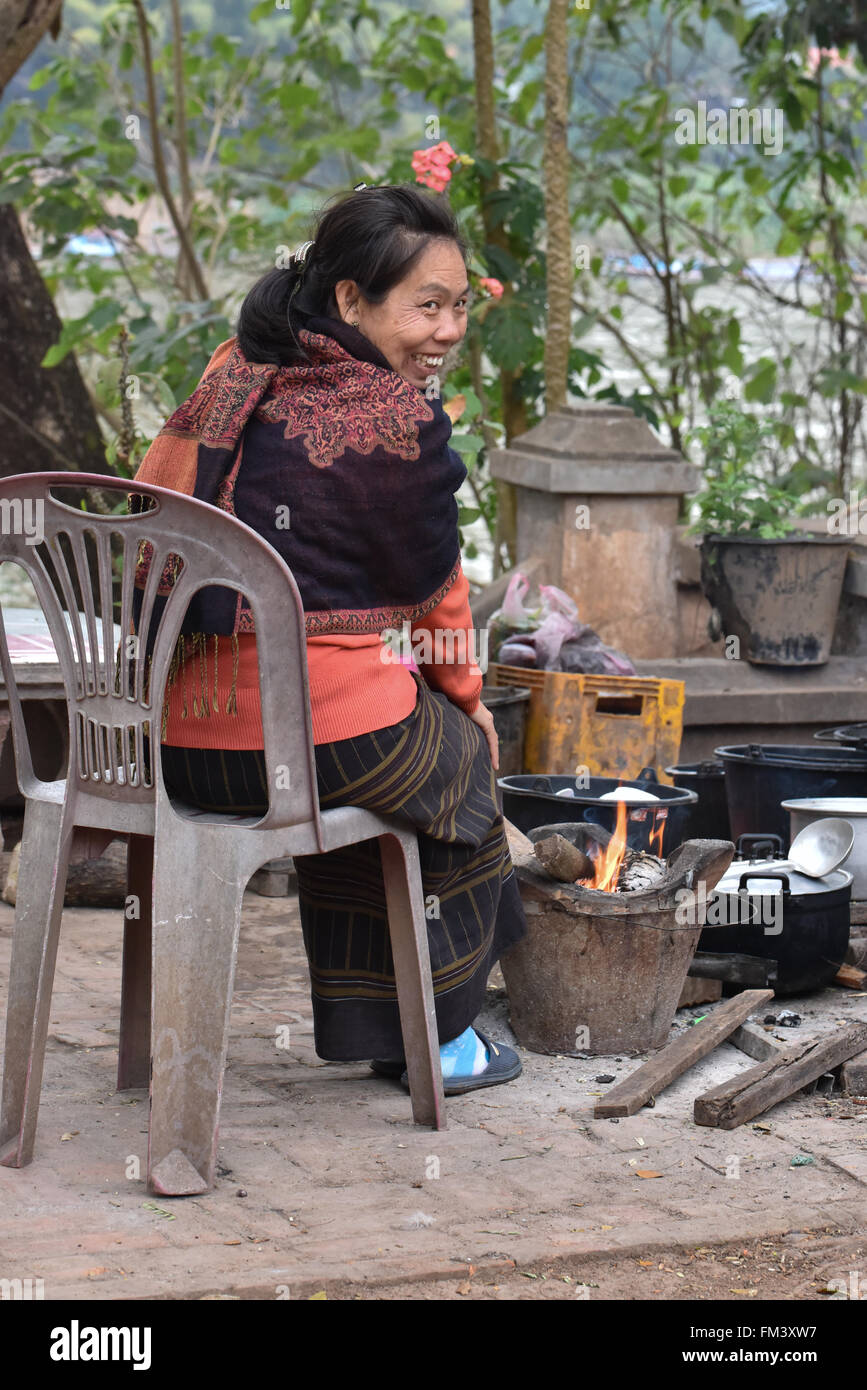 Vendor making a fire during intense cold front in Luang Prabang Laos ...