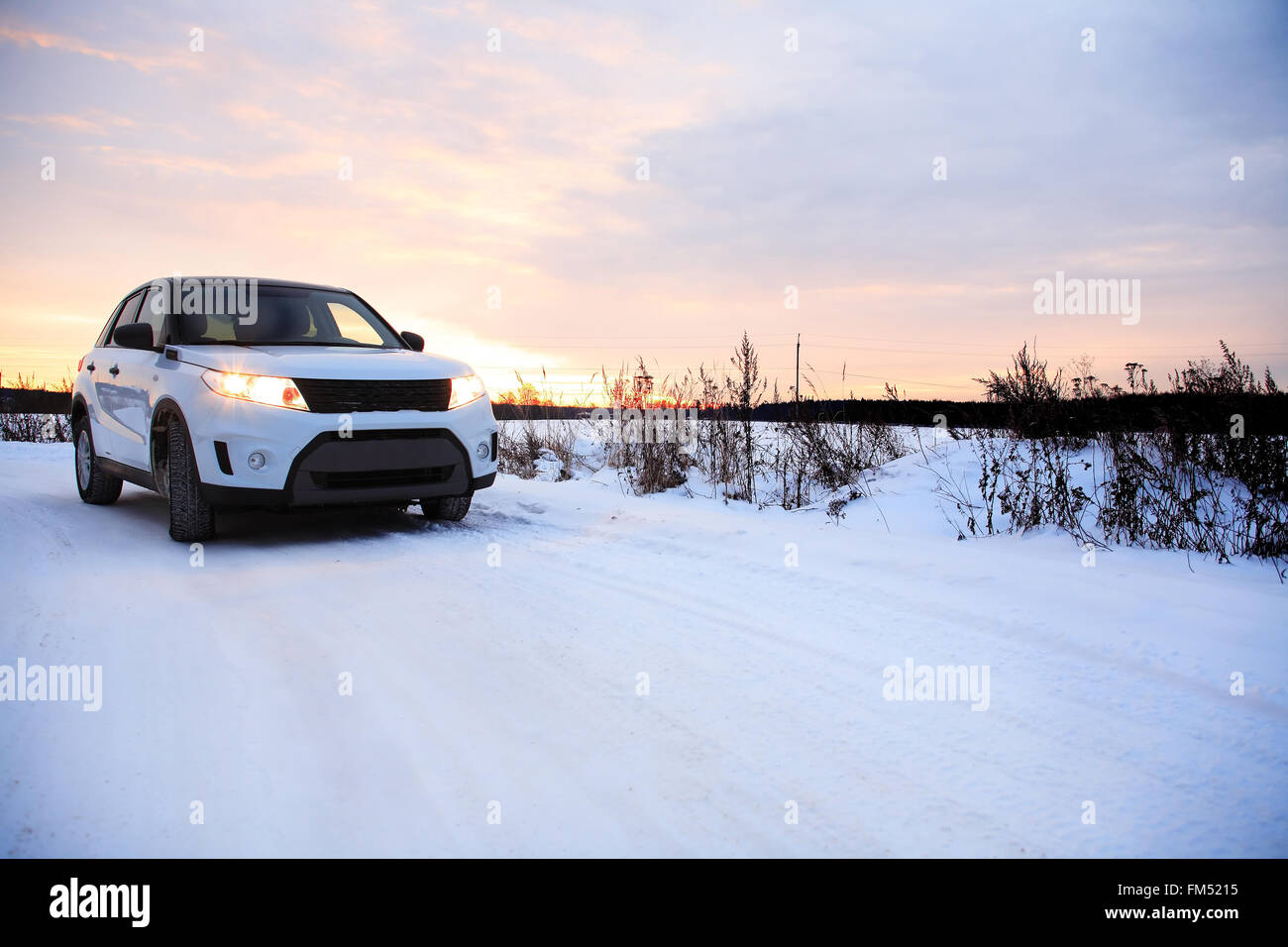 Modern car with glowing headlights on winter road at night Stock Photo ...