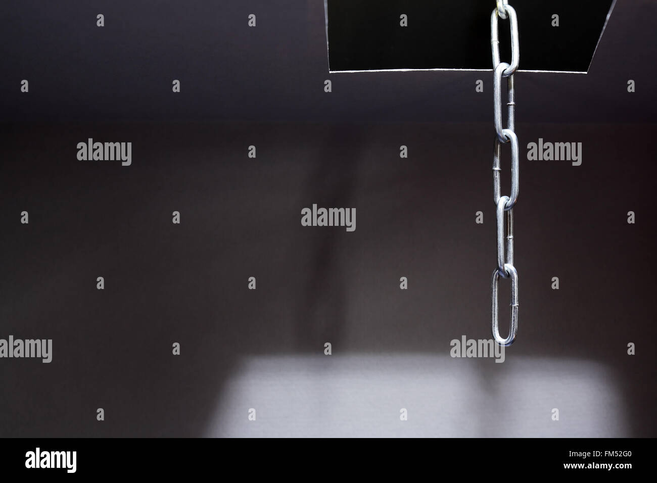 Escape concept. Metal chain inside hatch in ceiling Stock Photo - Alamy