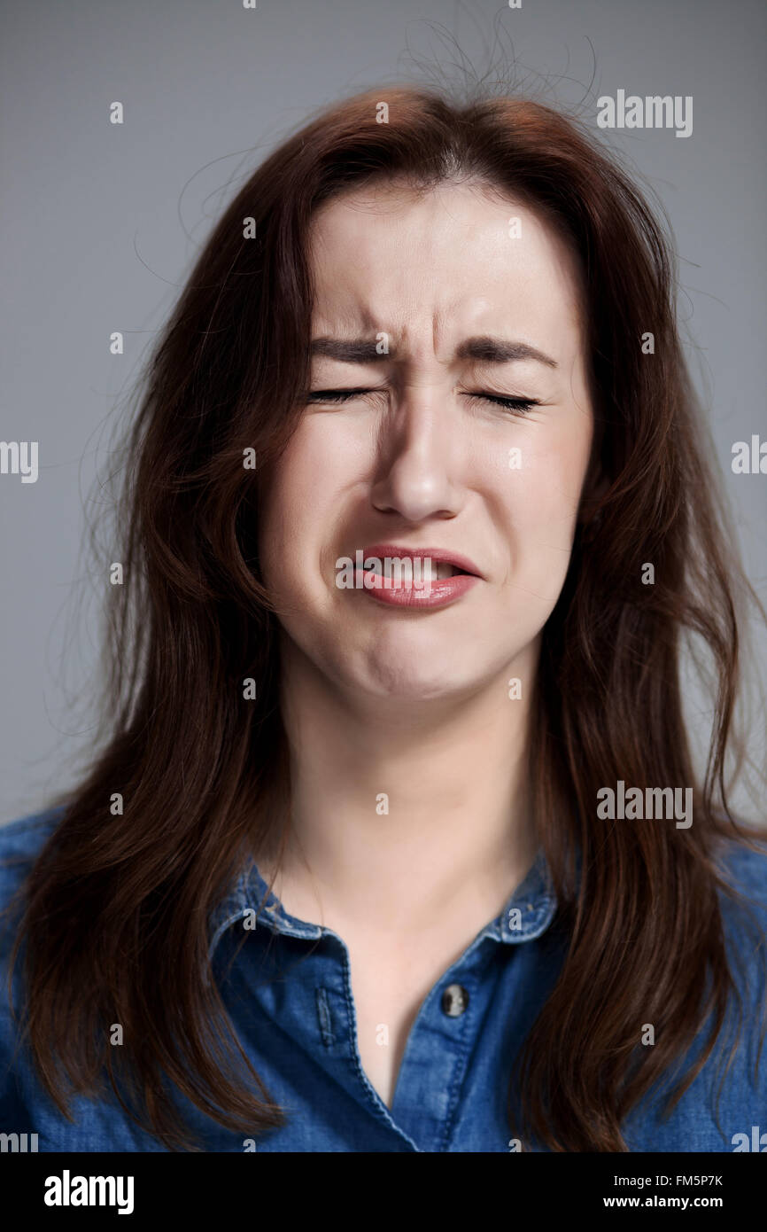 The crying woman closeup on gray background Stock Photo - Alamy