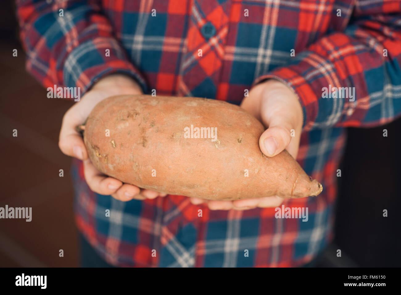 Boy holding sweet potato Stock Photo - Alamy