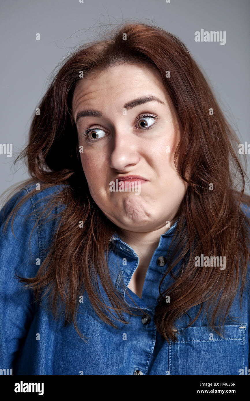 Portrait of young woman with shocked and surprised facial expressions ...