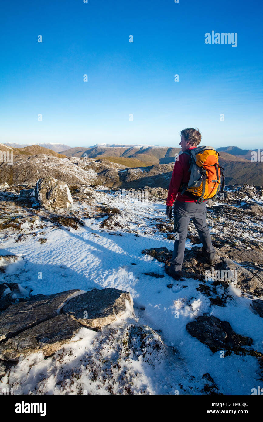 Winter walker at the summit of Knocknahillion, Maumturk Mountains ...