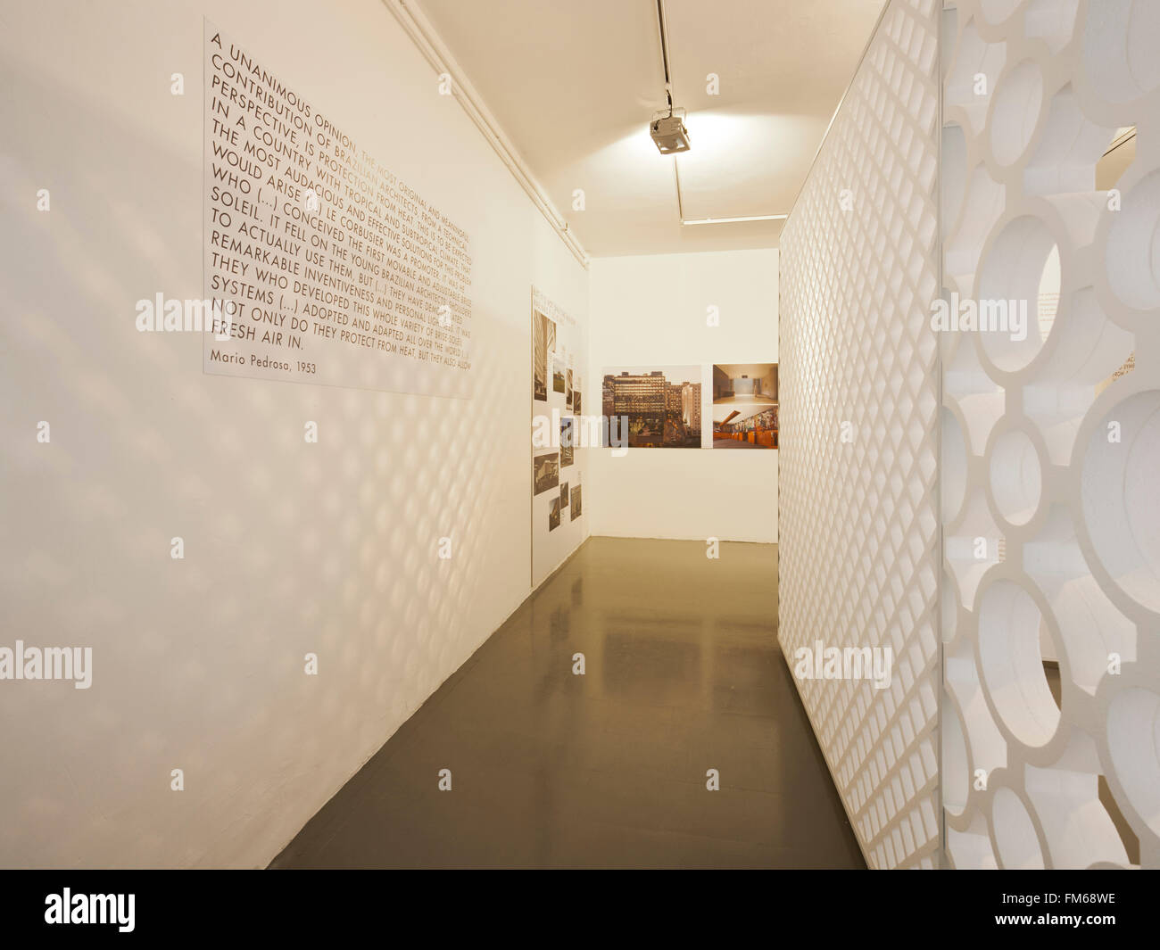 A passageway view towards a collection of artwork, hung in a modern ...
