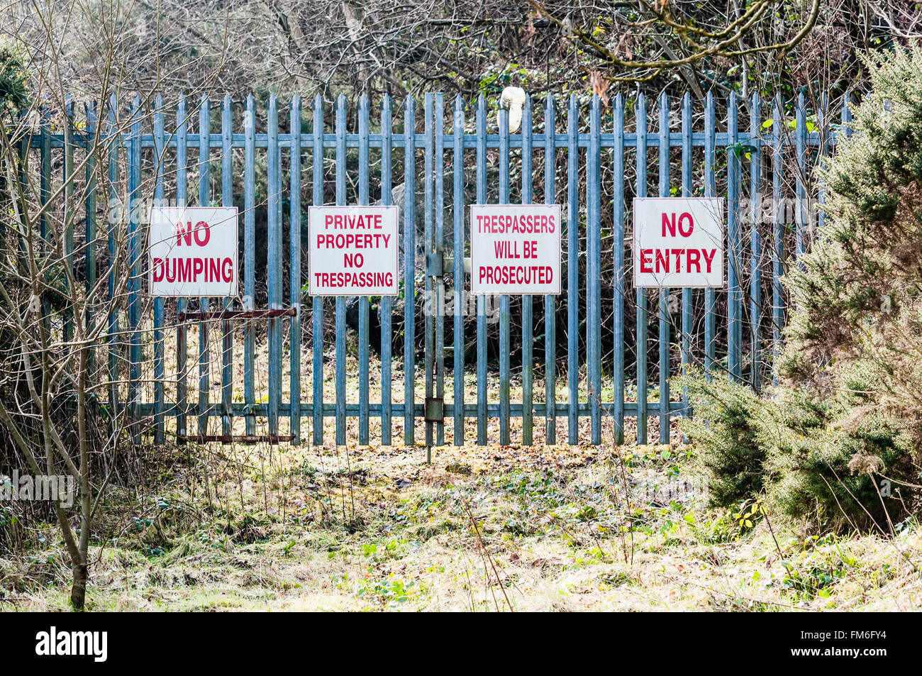 Signs on a security gate warning "No Dumping", "Private Property, No ...