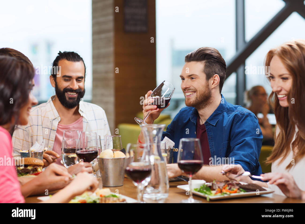 friends dining and drinking wine at restaurant Stock Photo - Alamy