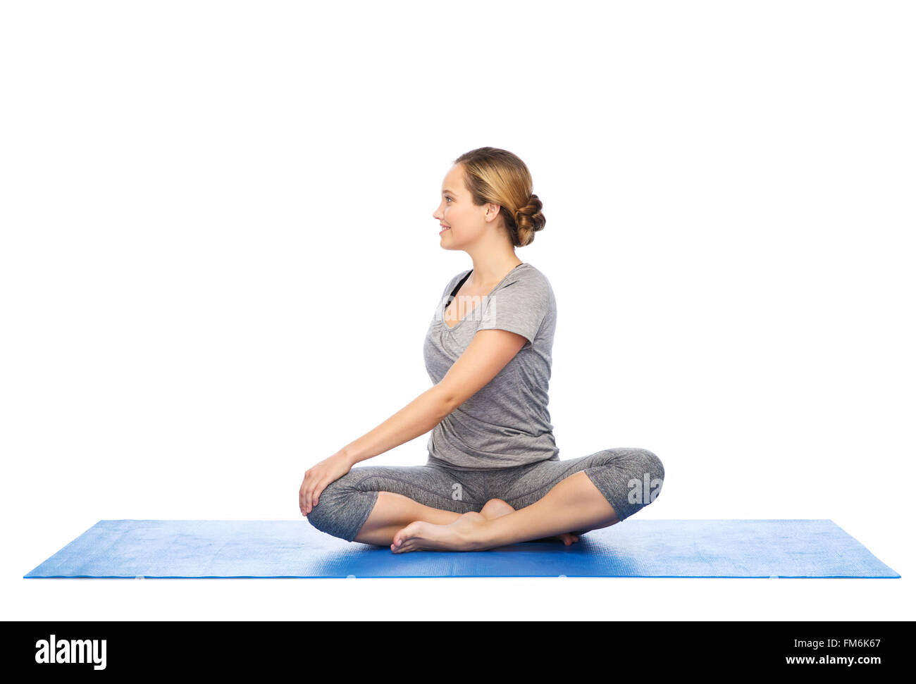 woman making yoga in twist pose on mat Stock Photo - Alamy