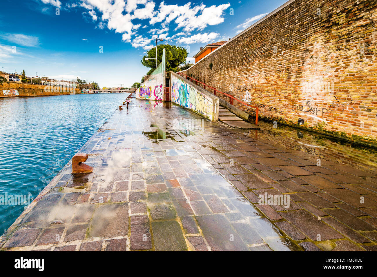 the Rimini canal port with graffiti, pigeons, bollards and moored boats ...