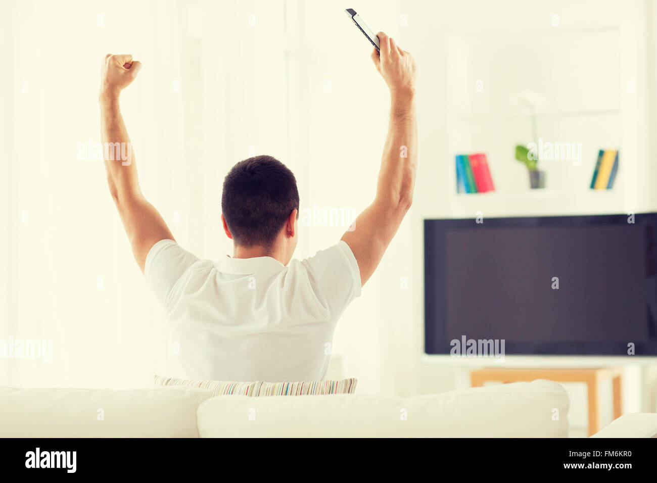 man watching tv and supporting team at home Stock Photo - Alamy