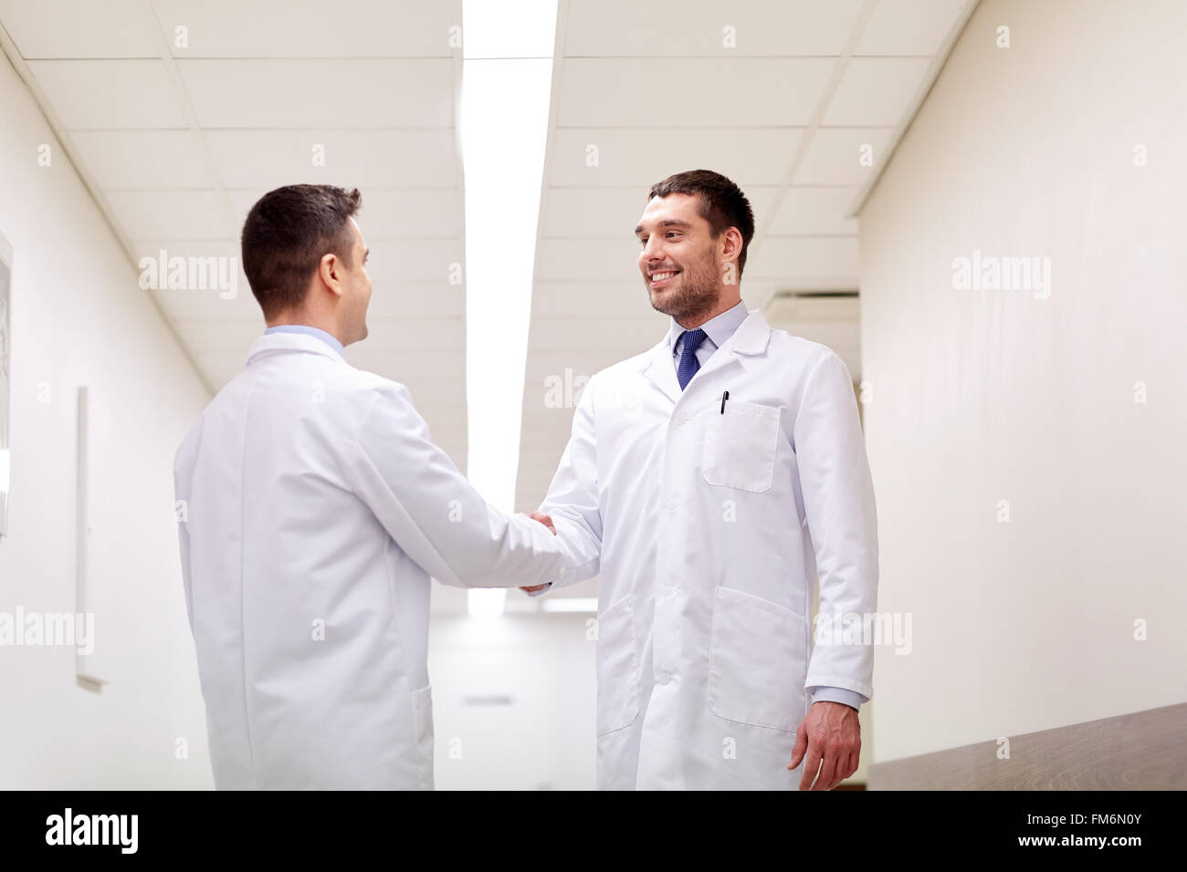 smiling doctors at hospital doing handshake Stock Photo - Alamy