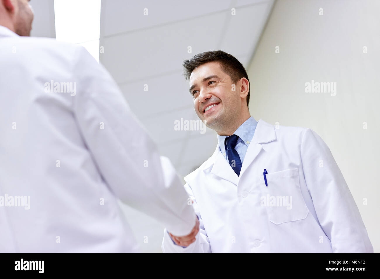 smiling doctors at hospital doing handshake Stock Photo - Alamy