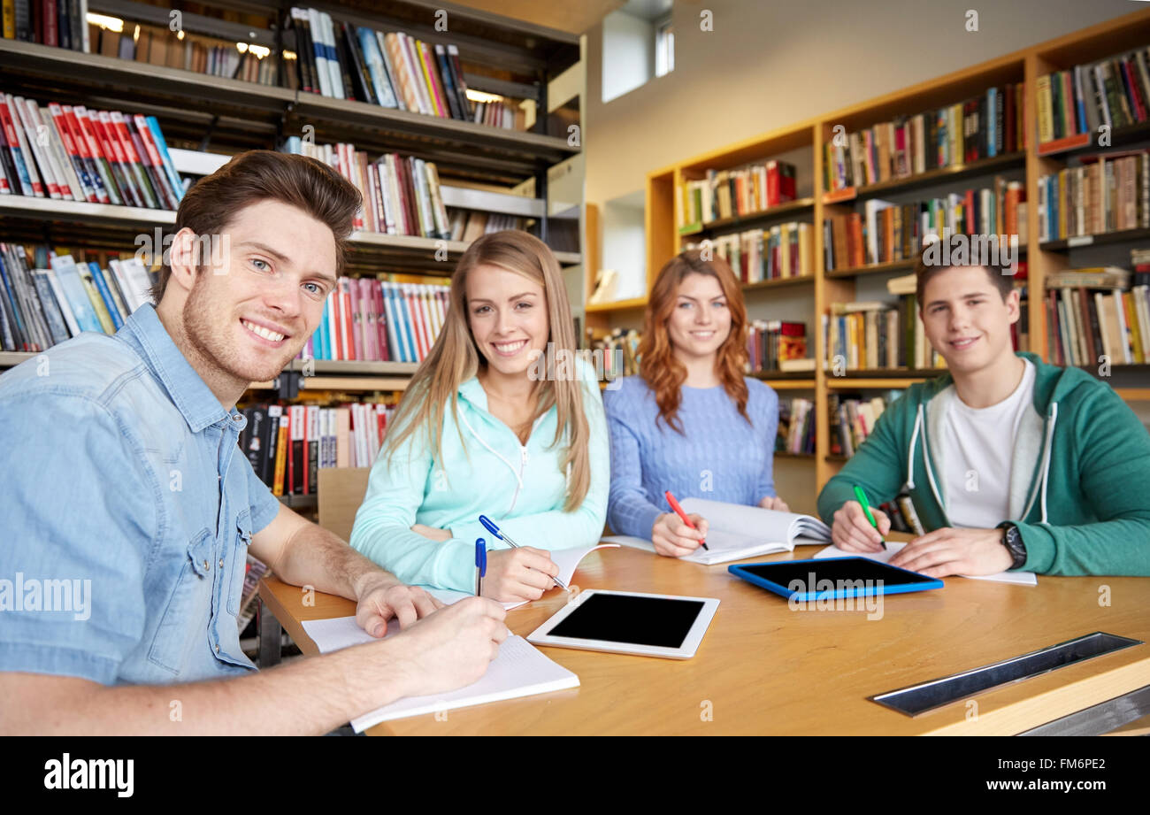 happy students writing to notebooks in library Stock Photo - Alamy