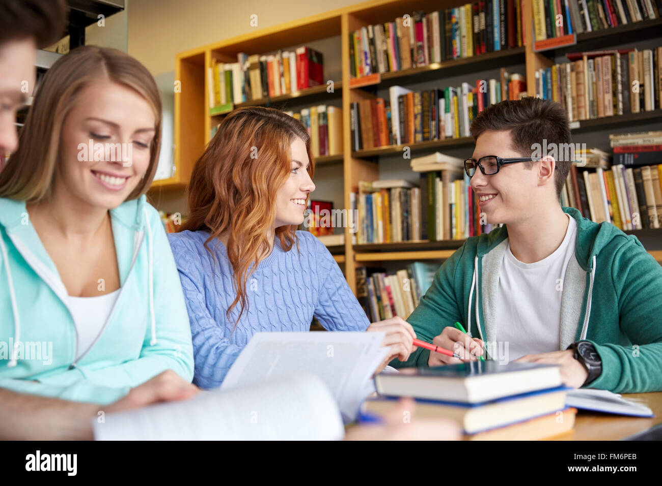 happy students writing to notebooks in library Stock Photo - Alamy