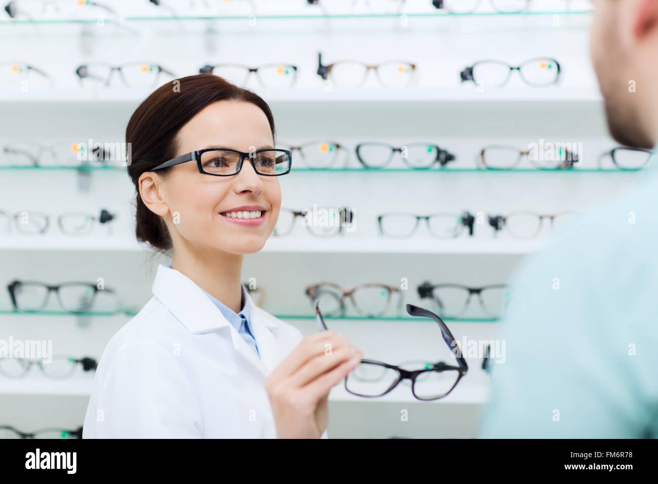optician showing glasses to man at optics store Stock Photo - Alamy