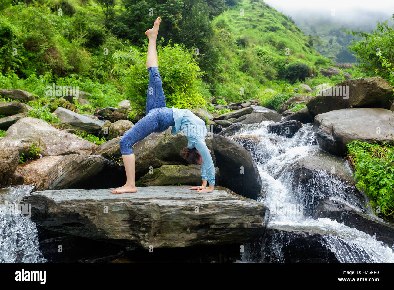 Woman doing yoga asana at waterfall Stock Photo - Alamy